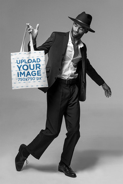 Placeit - Mockup of an Elegant Man Holding a Tote Bag at a Studio