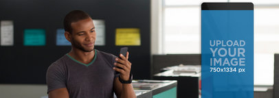 Placeit - Young Man Using His Smartphone at his Workstation