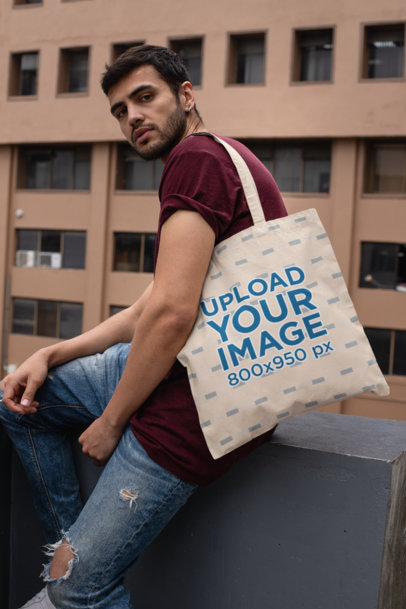 Placeit - Mockup of a Trendy Man Posing with a Tote Bag on the Street