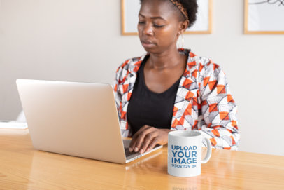 Placeit - Mockup of a Woman with an 11 oz Mug Working from Home