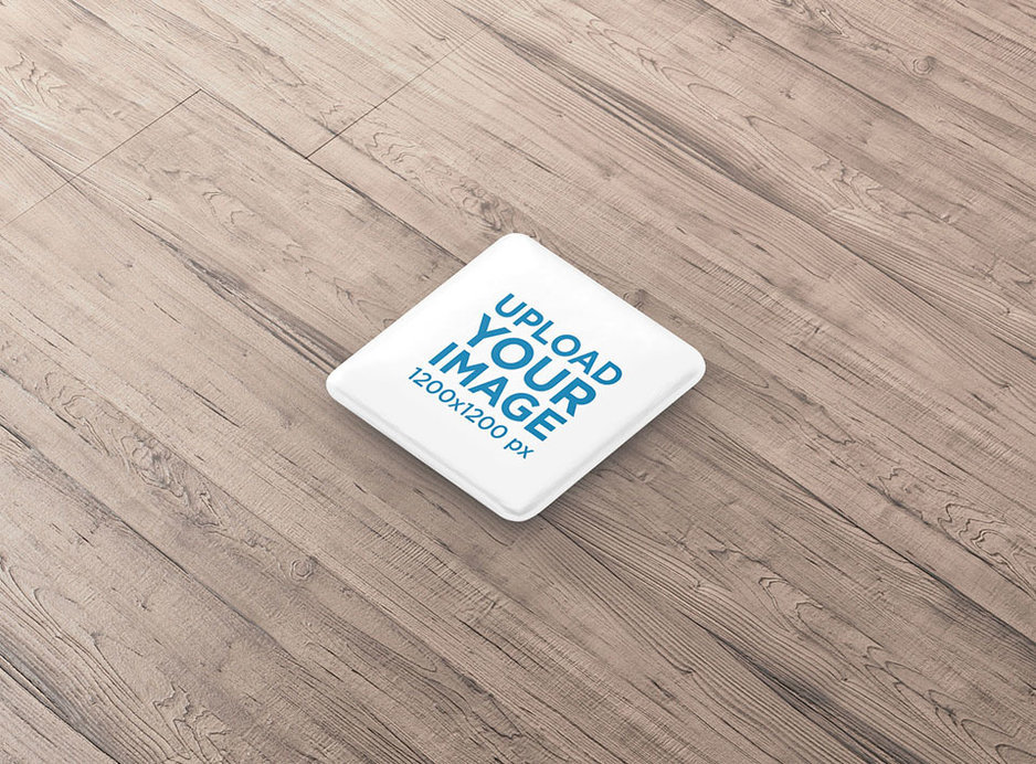 Placeit - Mockup Featuring a Square Pin Button Placed on a Wooden Surface