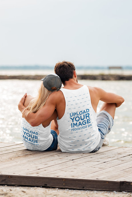 Placeit - Back View Mockup of a Couple with Tank Tops Hugging at The Beach